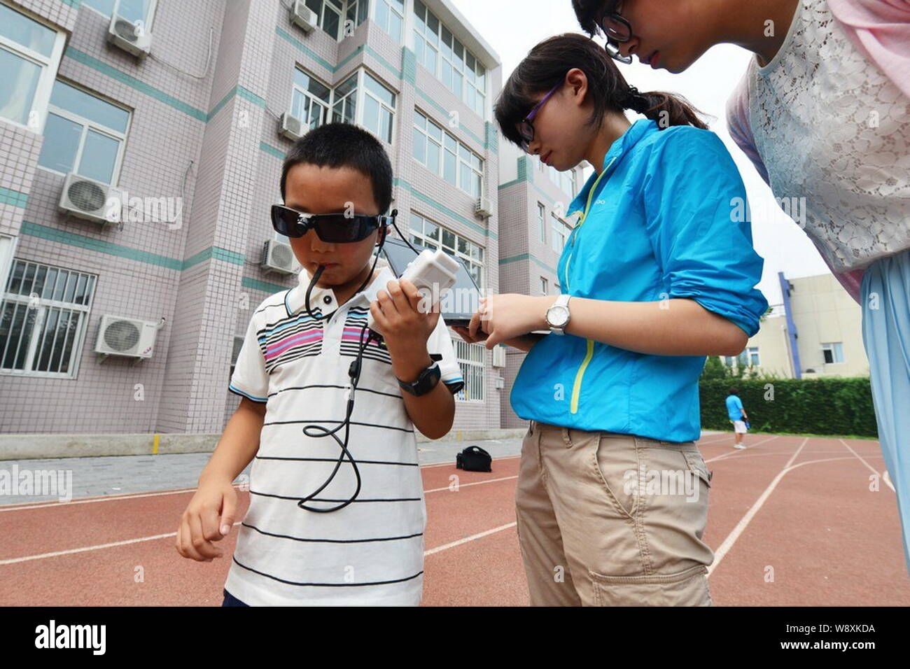 A staff member tests the magnetic electronic device worn by 7-year-old ...