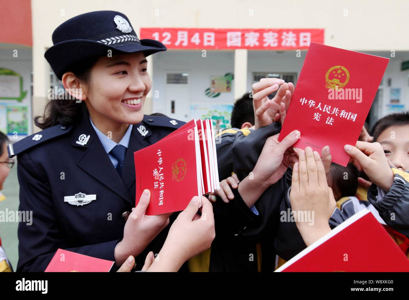 A Chinese policewoman hands out copies of the Constitution of the ...