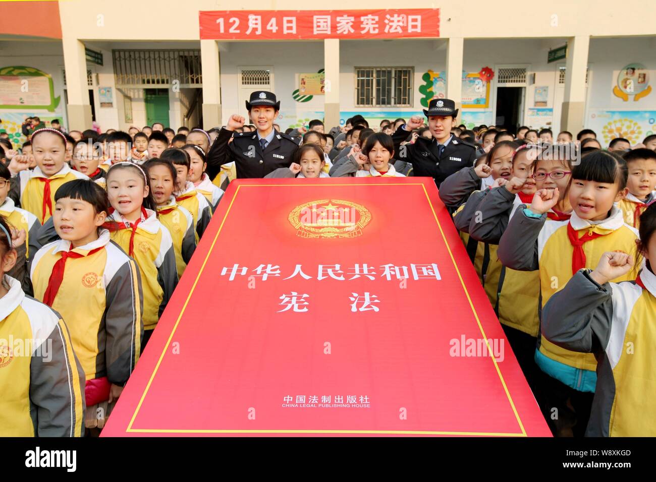 Young Chinese students and police officers swear an oath around a giant ...