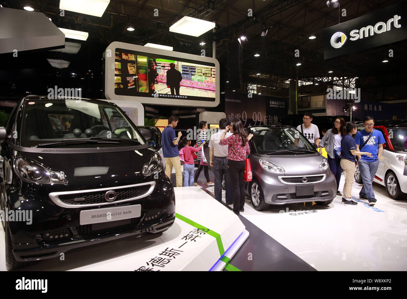--FILE--Visitors look at Smart compact cars of Mercedes-Benz on display ...