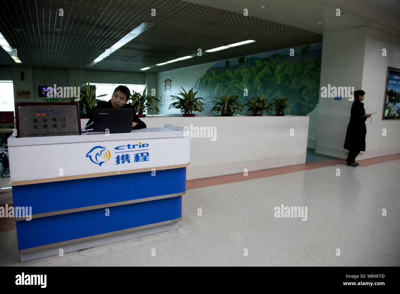 --FILE--A Chinese employee works at the counter of online travel agency ...