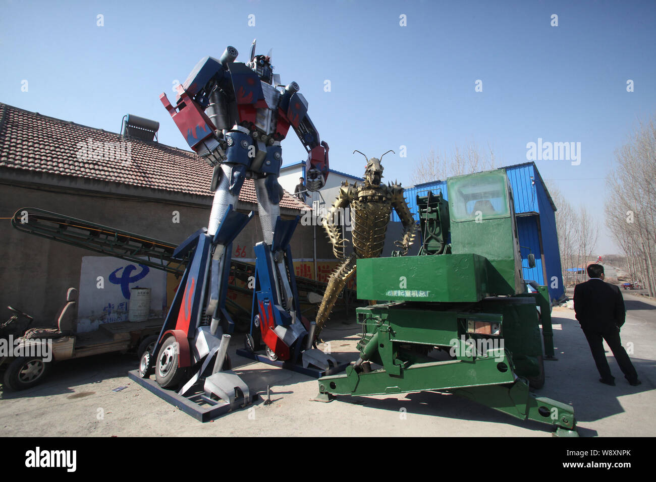--FILE--A Chinese man stands next to a replica of Optimus Prime, left ...