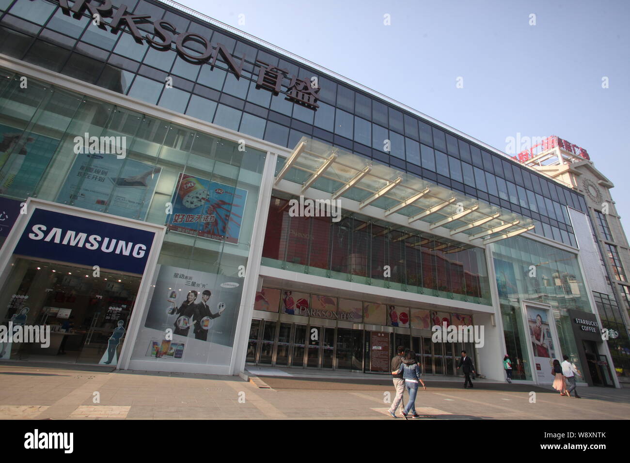 Pedestrians walk past the closed department store of Parkson in JiNan ...