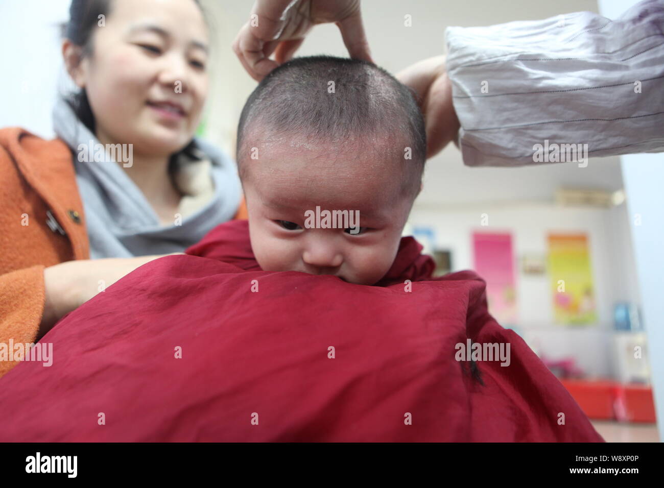 A Chinese kid has his hair cut at the barbers on Dragon Heads-raising ...