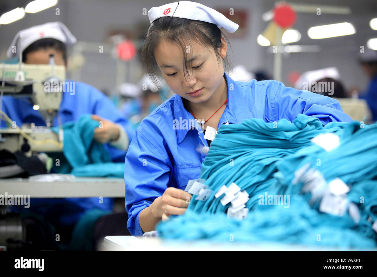 --FILE--Female Chinese workers sew tee shirts to be exported at a garment factory of Jifa Group ...