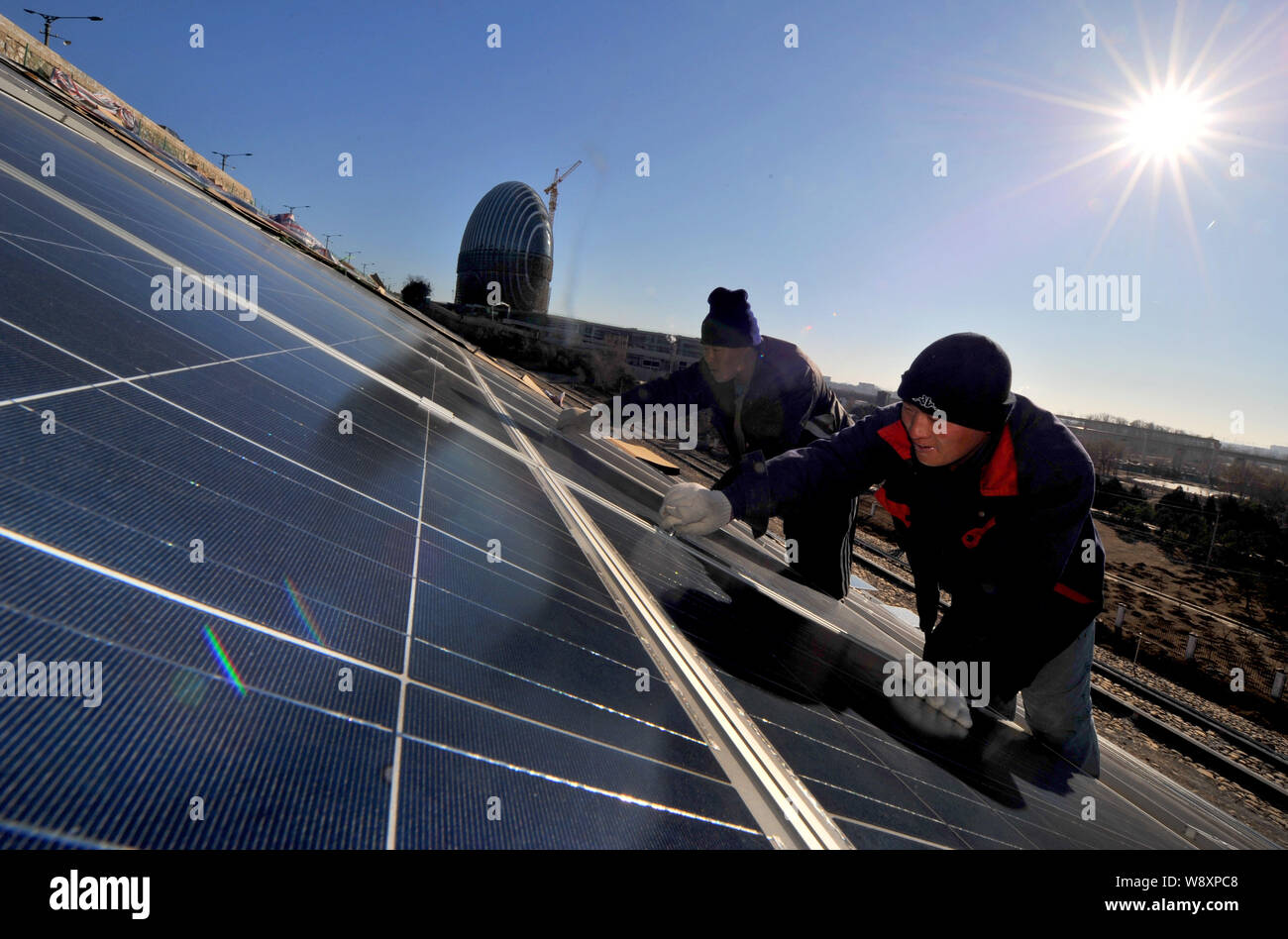 --FILE--Chinese workers install solar panels at a photovoltaic power ...