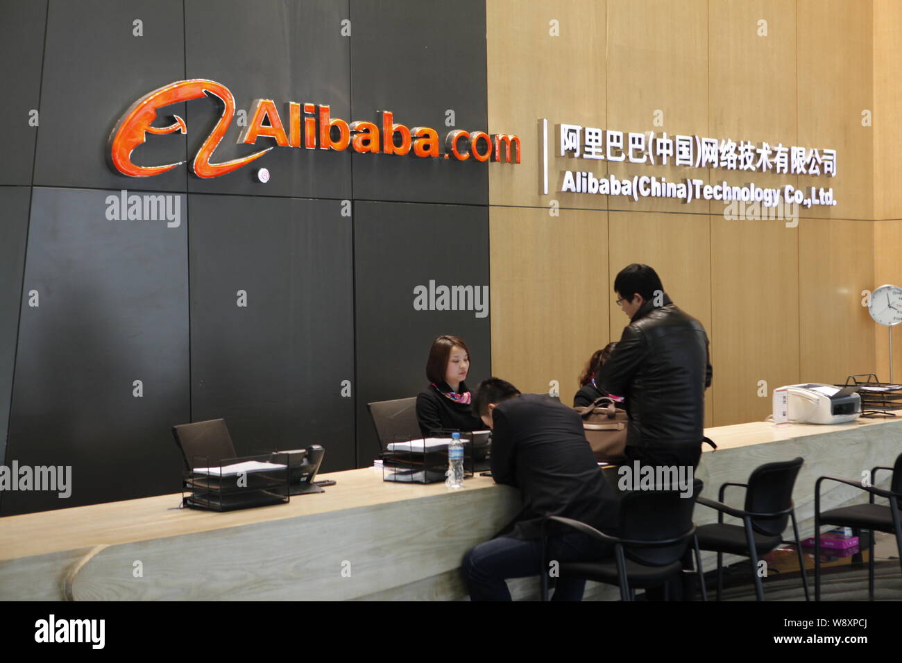 --FILE--Chinese employees serve visitors at the reception desk in the ...
