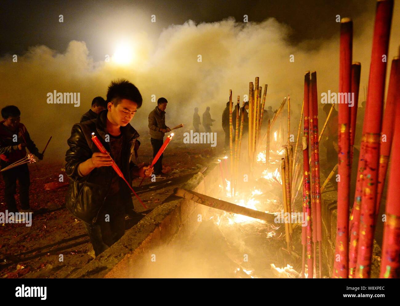Chinese worshippers burn candles and incense sticks to pray for good ...