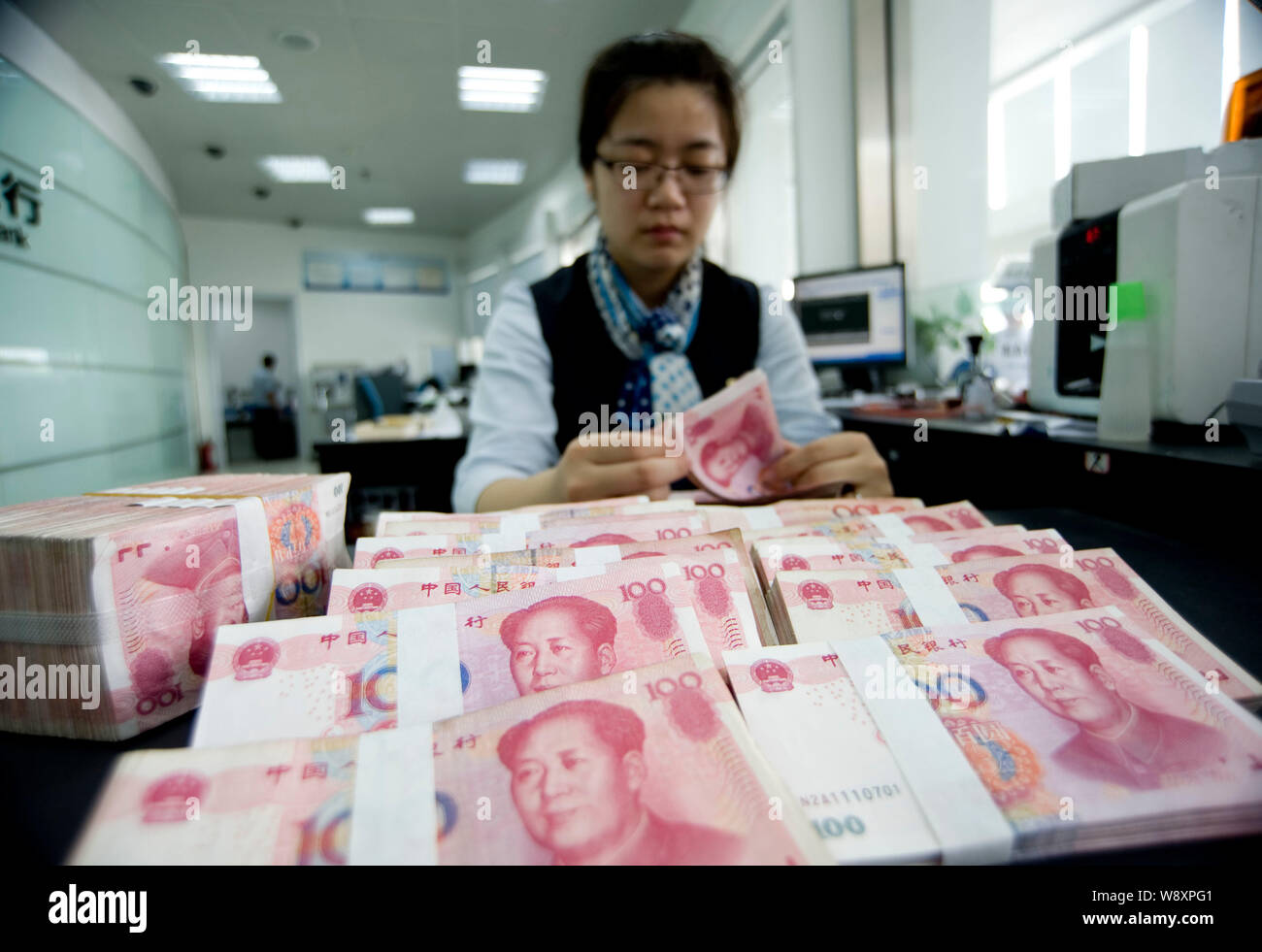 --FILE--A Chinese clerk counts RMB (renminbi) yuan banknotes at a bank ...