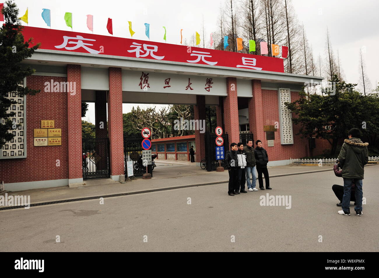 --FILE--Students pose for photos in front of the entrance of Fudan ...