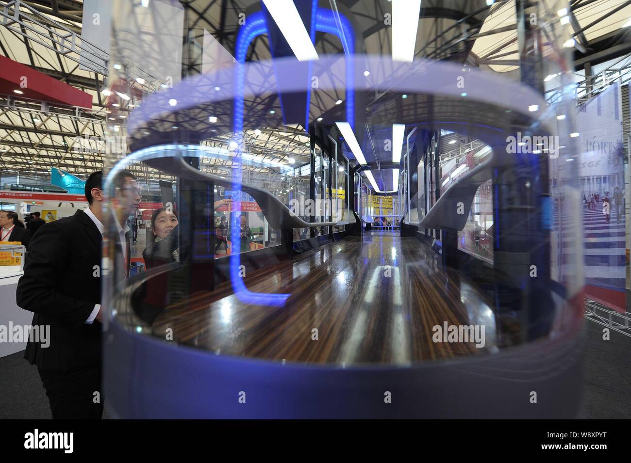 Visitors look at a model of a suspended monorail system on display at ...