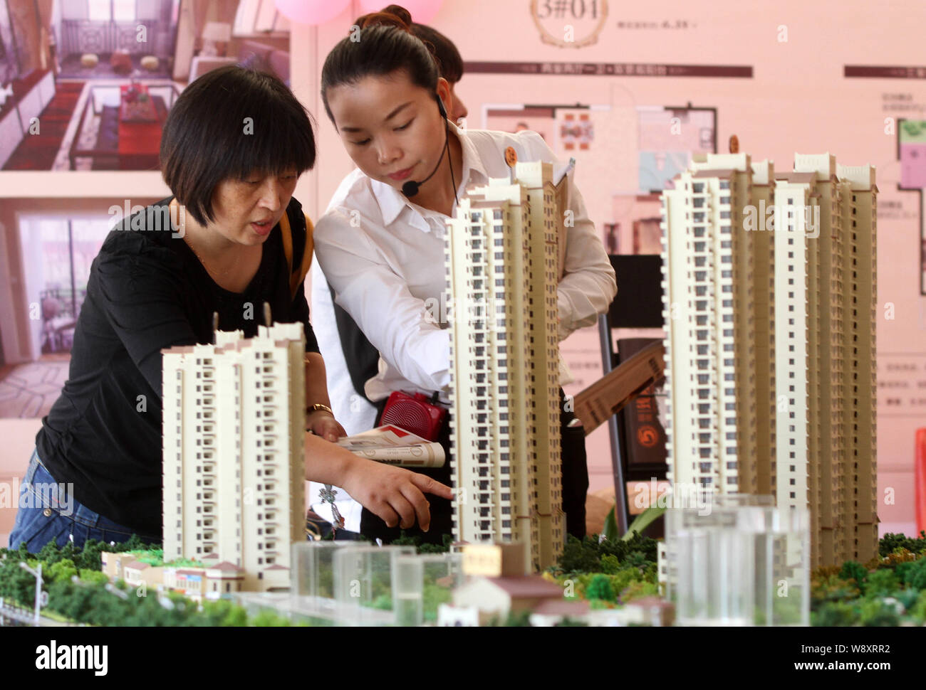 --FILE--A Chinese employee introduces models of residential apartment ...