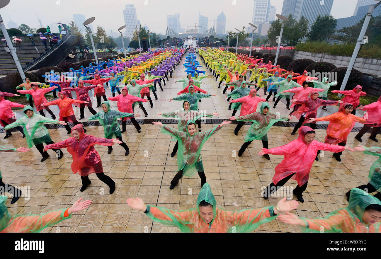 Chinese residents braving the rain take part in a mass dance event at ...
