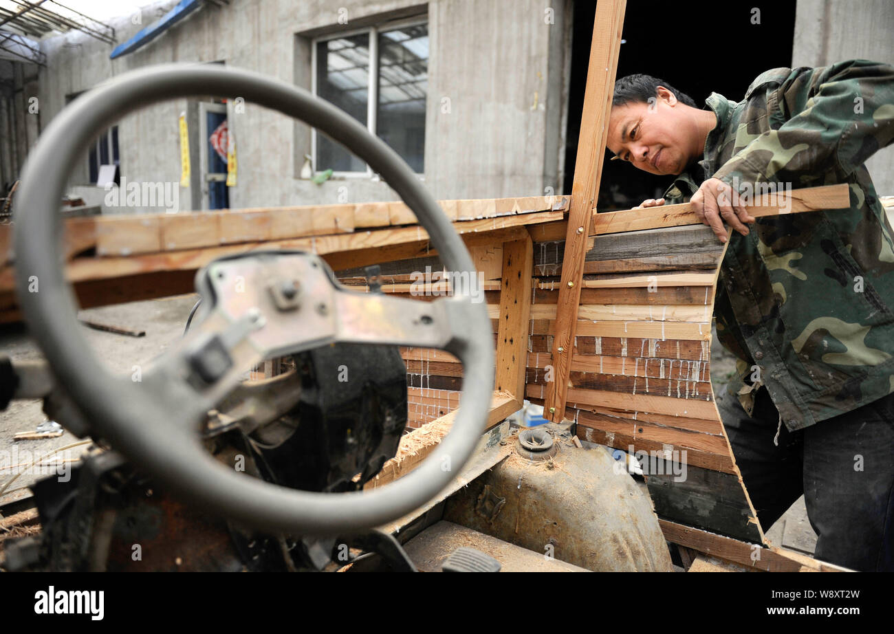 Chinese carpenter Liu Fulong repairs his homemade wooden electric car ...