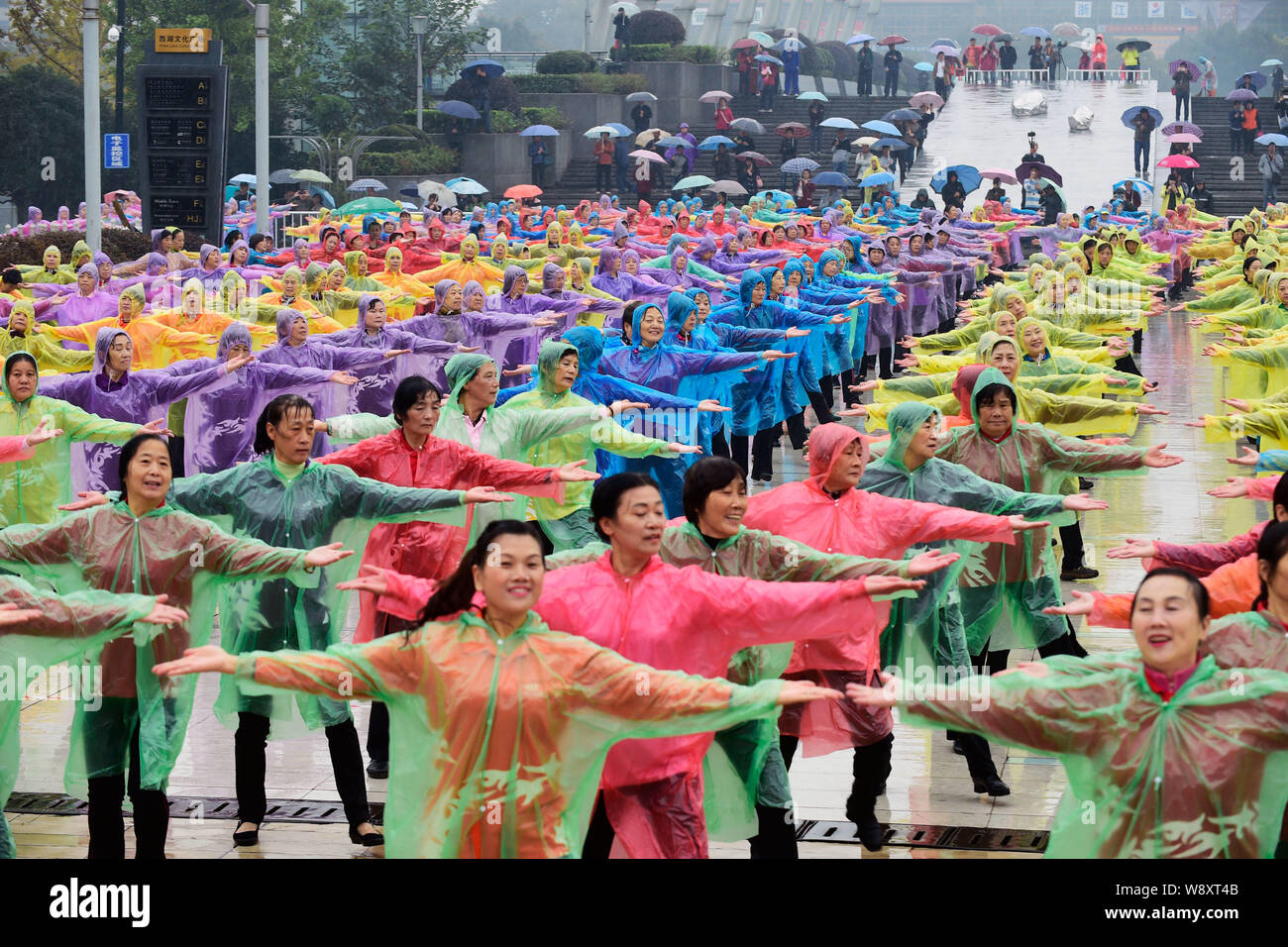 Chinese residents braving the rain take part in a mass dance event at ...