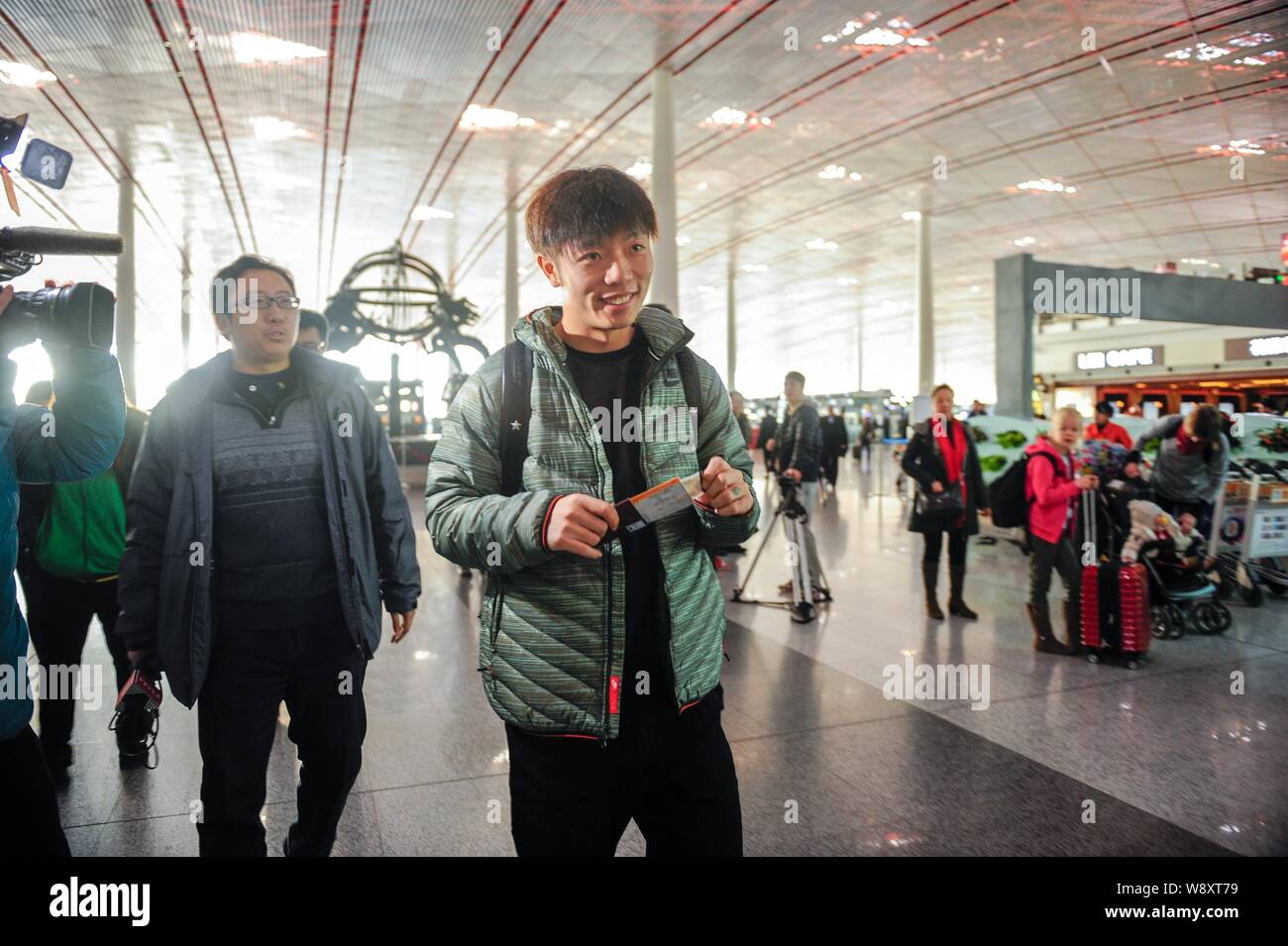 Chinese footballer Zhang Xizhe, front, arrives at the Beijing Capital ...