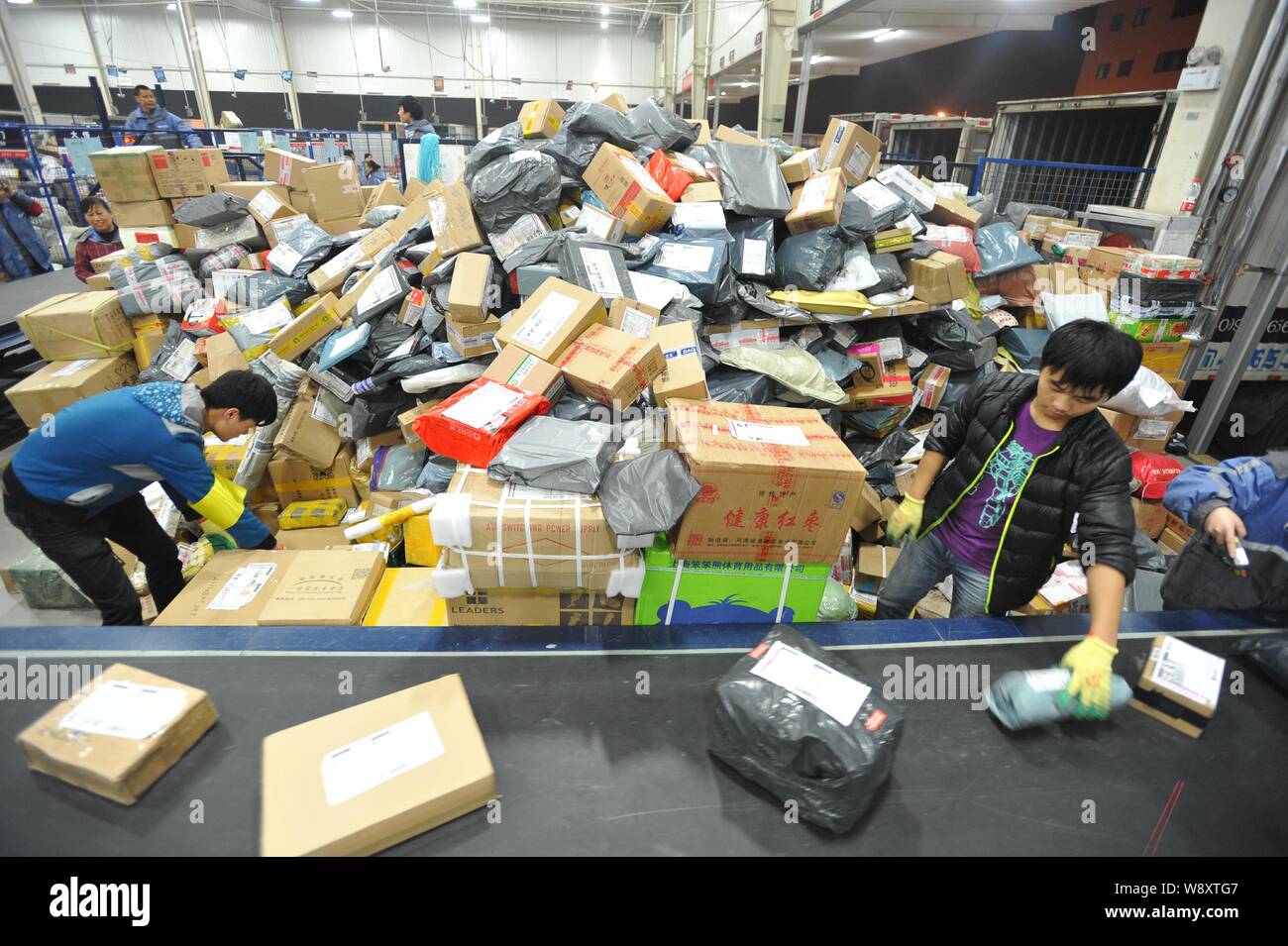 Chinese workers sort parcels, most of which are from online shopping ...