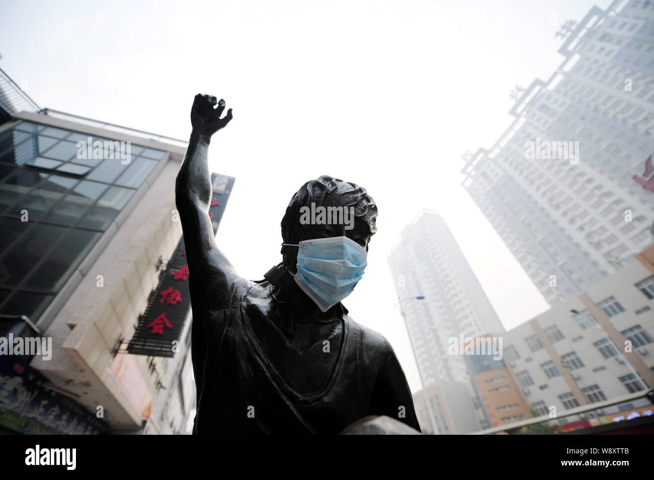 A sculpture is seen wearing a face mask in heavy smog in Luoyang city ...