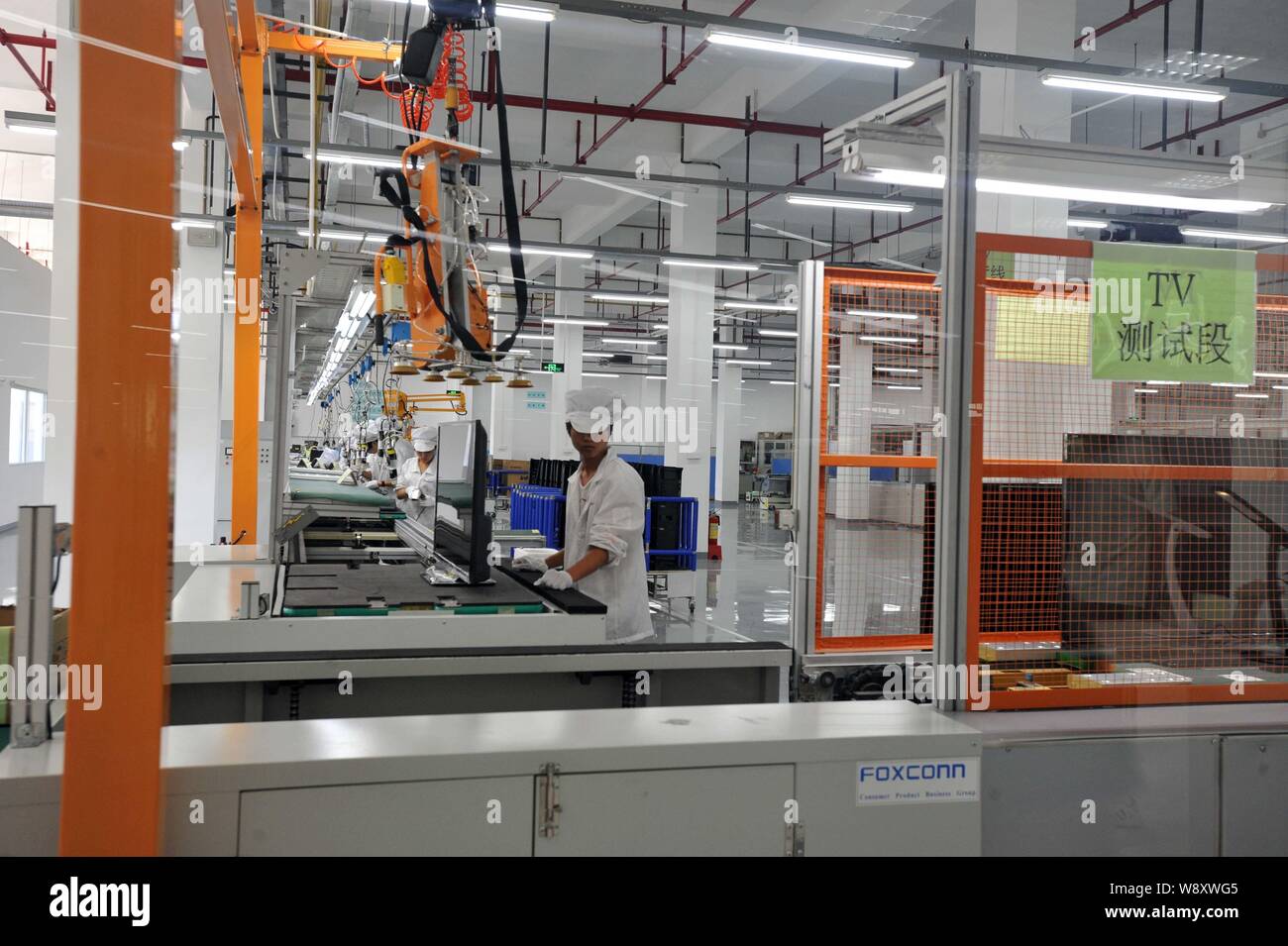 Chinese workers produce parts of televisions on an assembly line at the ...