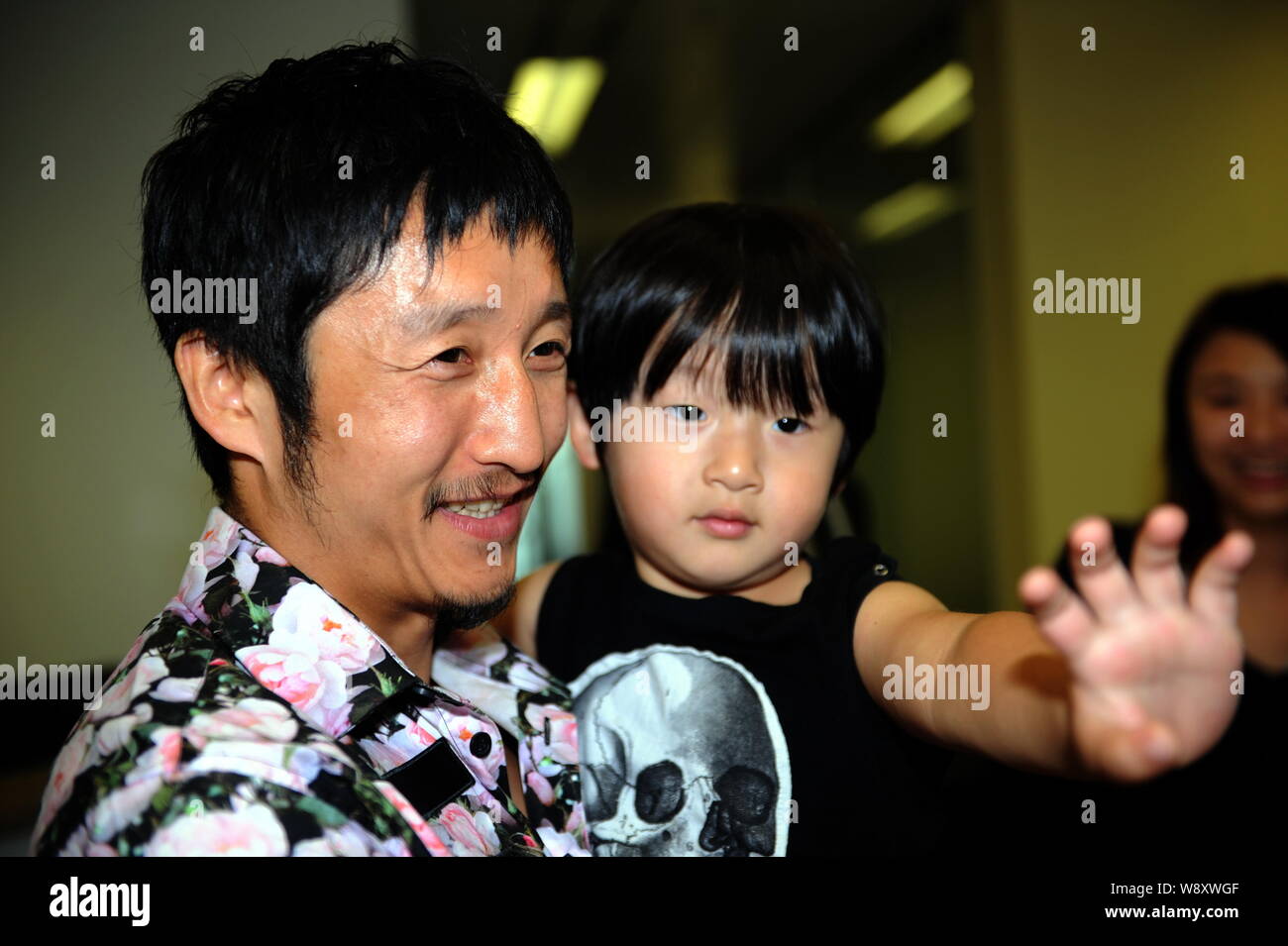 Chinese boxer Zou Shiming, left, smiles as he holds his son at an ...