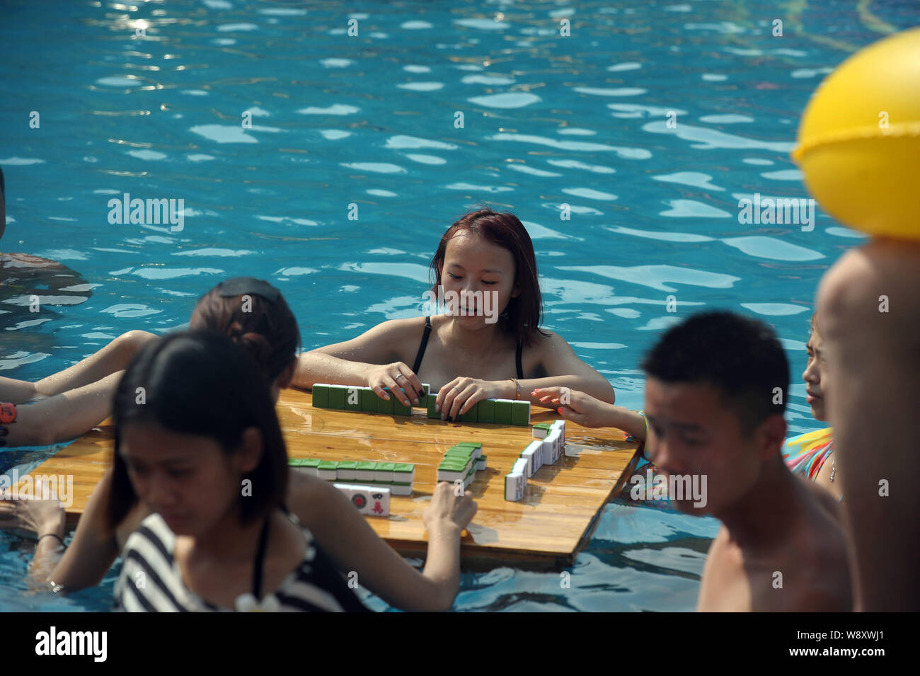 Chinese holidaymakers play mahjong in the water at a water park in ...