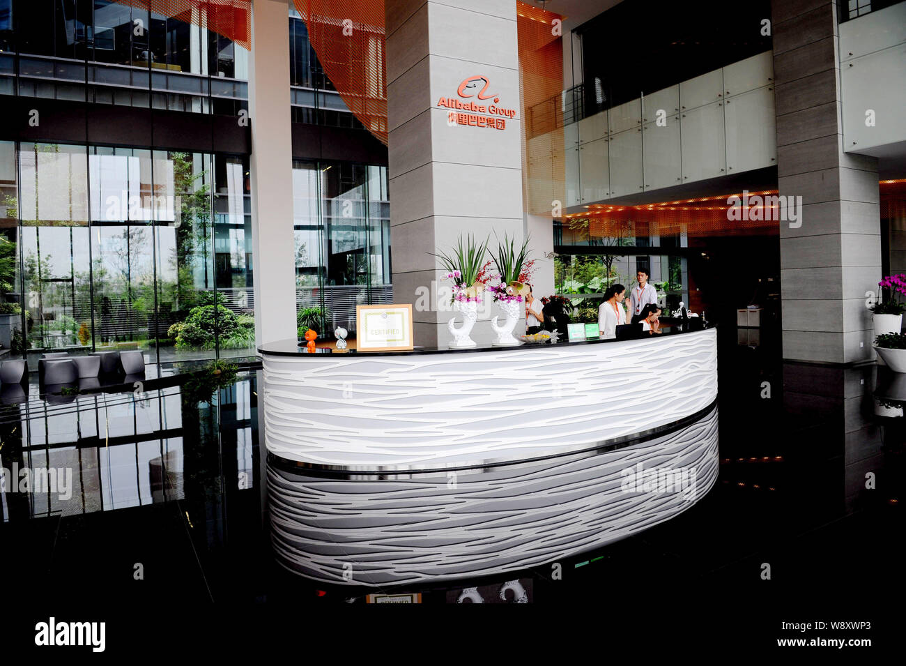 Chinese employees work at the front desk of the headquarters of Alibaba ...