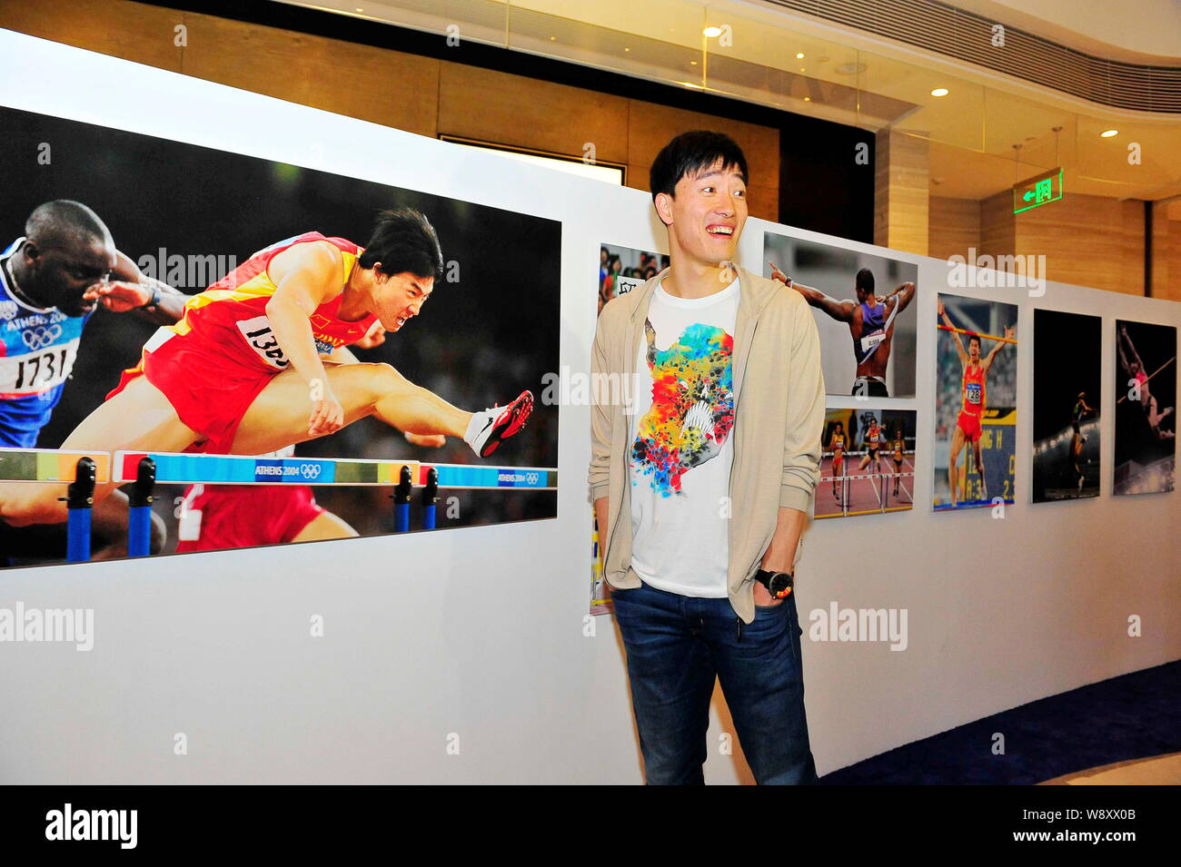 Chinese star hurdler Liu Xiang poses in front of photos showing him ...