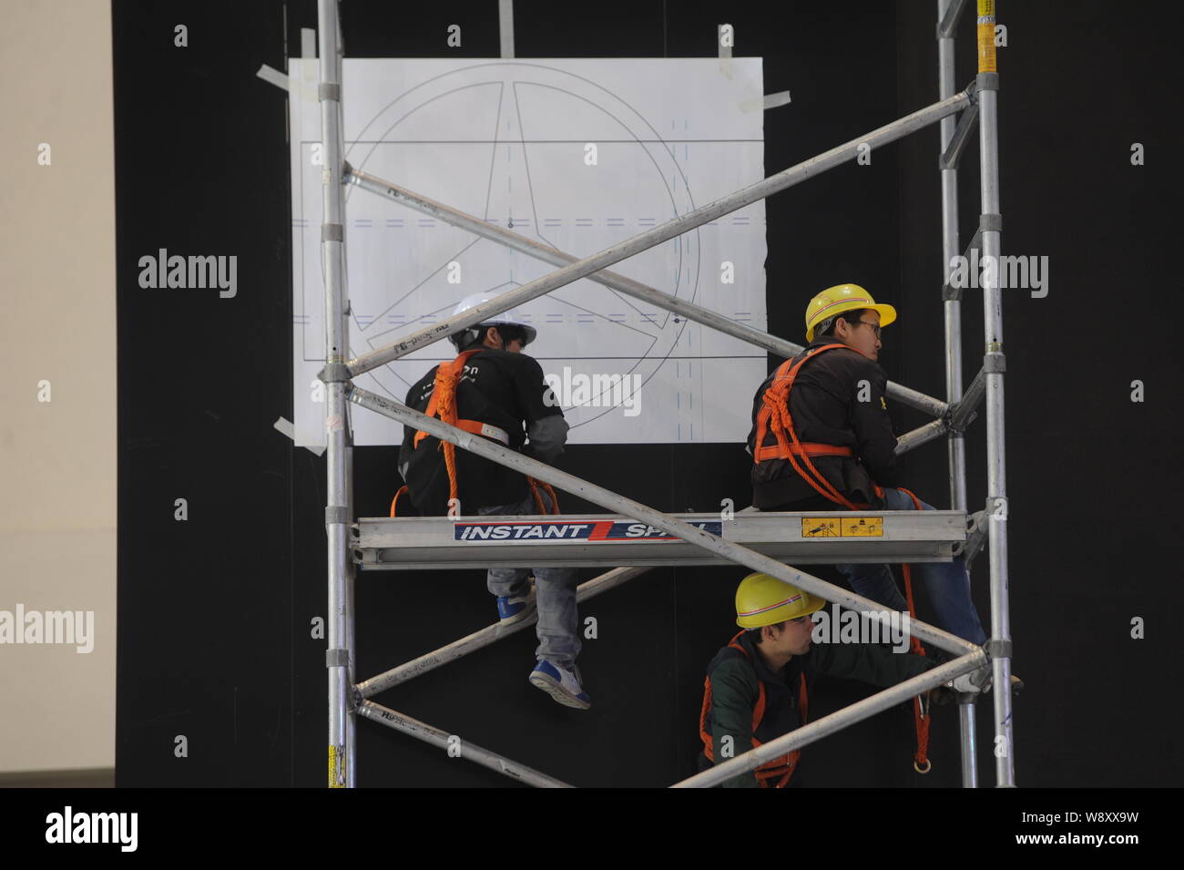 Workers rest on a scaffold at the stand of Mercedes-Benz in preparation ...