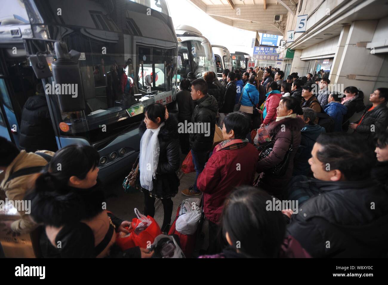 Chinese passengers wait to board buses at a long-distance bus station ...