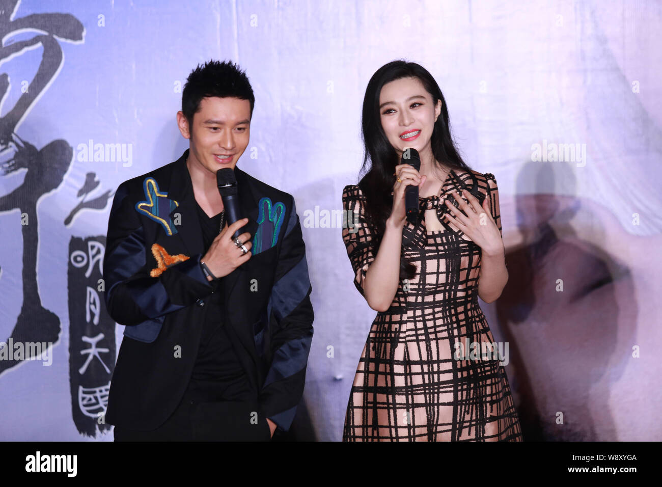 Chinese actor Huang Xiaoming, left, speaks as actress Fan Bingbing ...