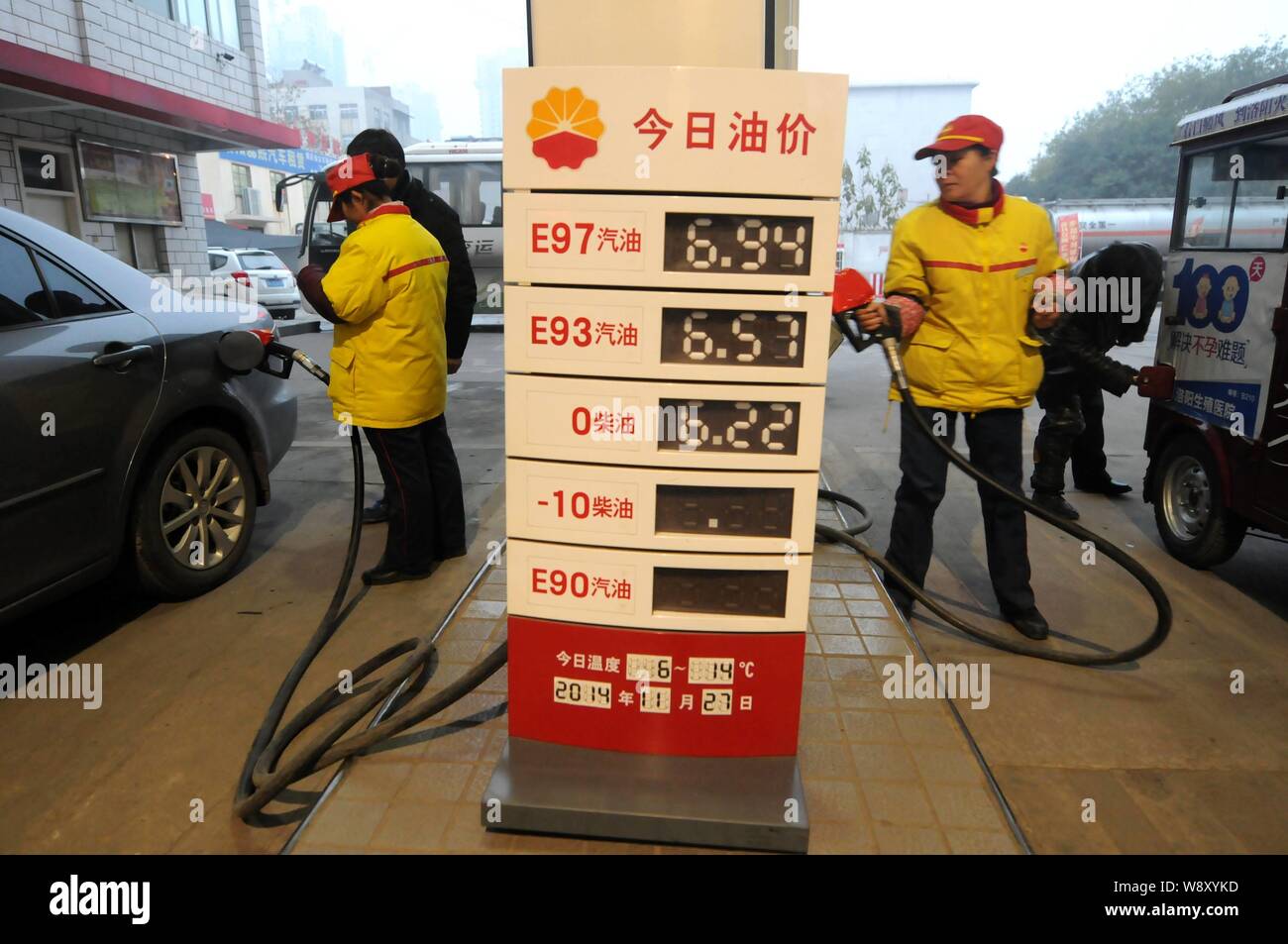 --FILE--Chinese employees refuel cars at a gas station of PetroChina, a ...