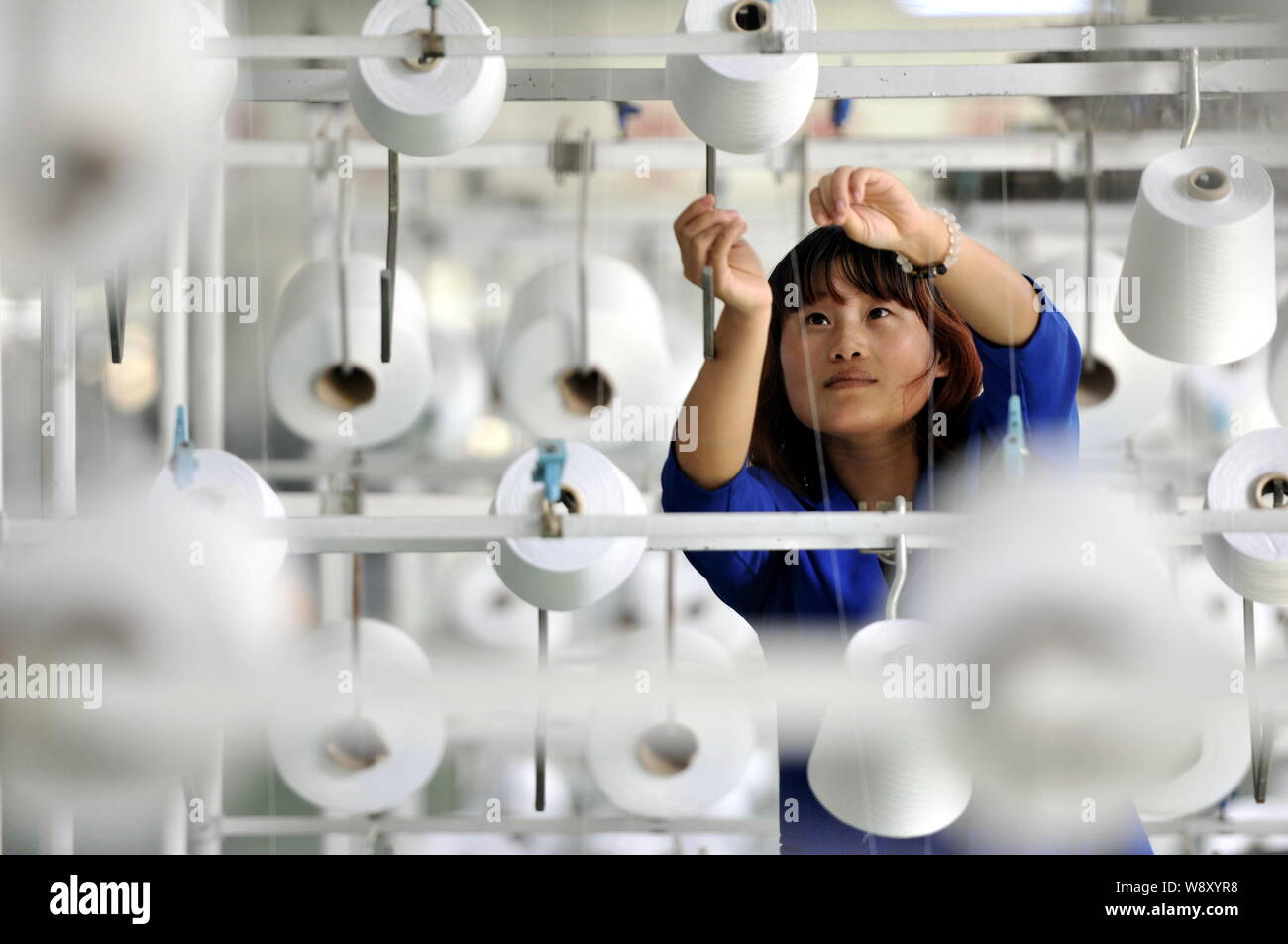--FILE--A female Chinese worker handles production of yarn at a textile factory in Linyi city ...