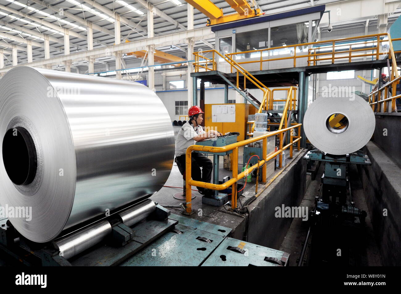 --FILE--A Chinese worker monitors the production of coiled aluminum ...