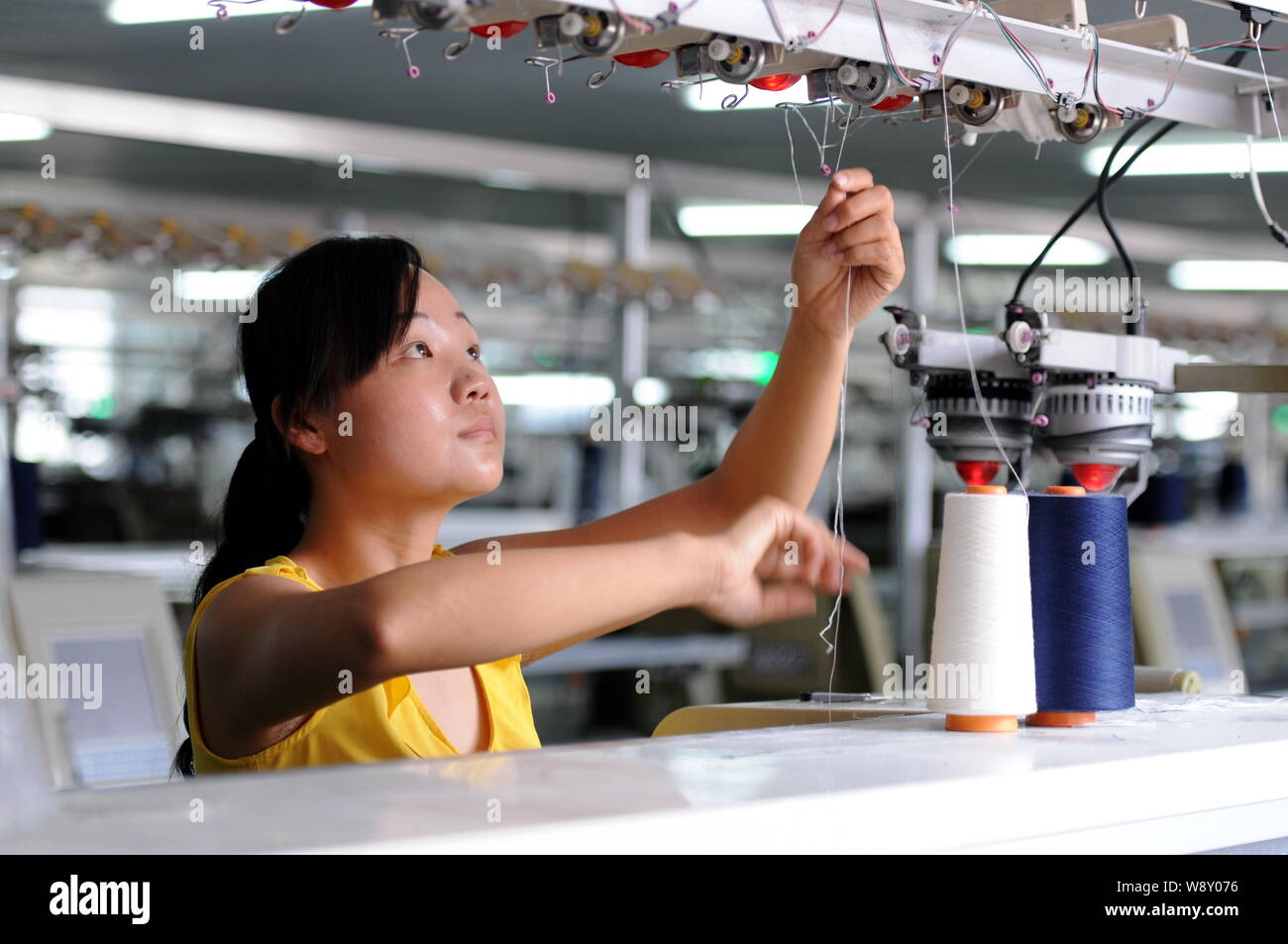 --FILE--A female Chinese worker sews clothes to be exported at a garment factory in Tancheng ...