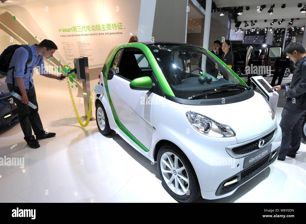 Visitors look at a Smart electric car during the 13th Beijing ...