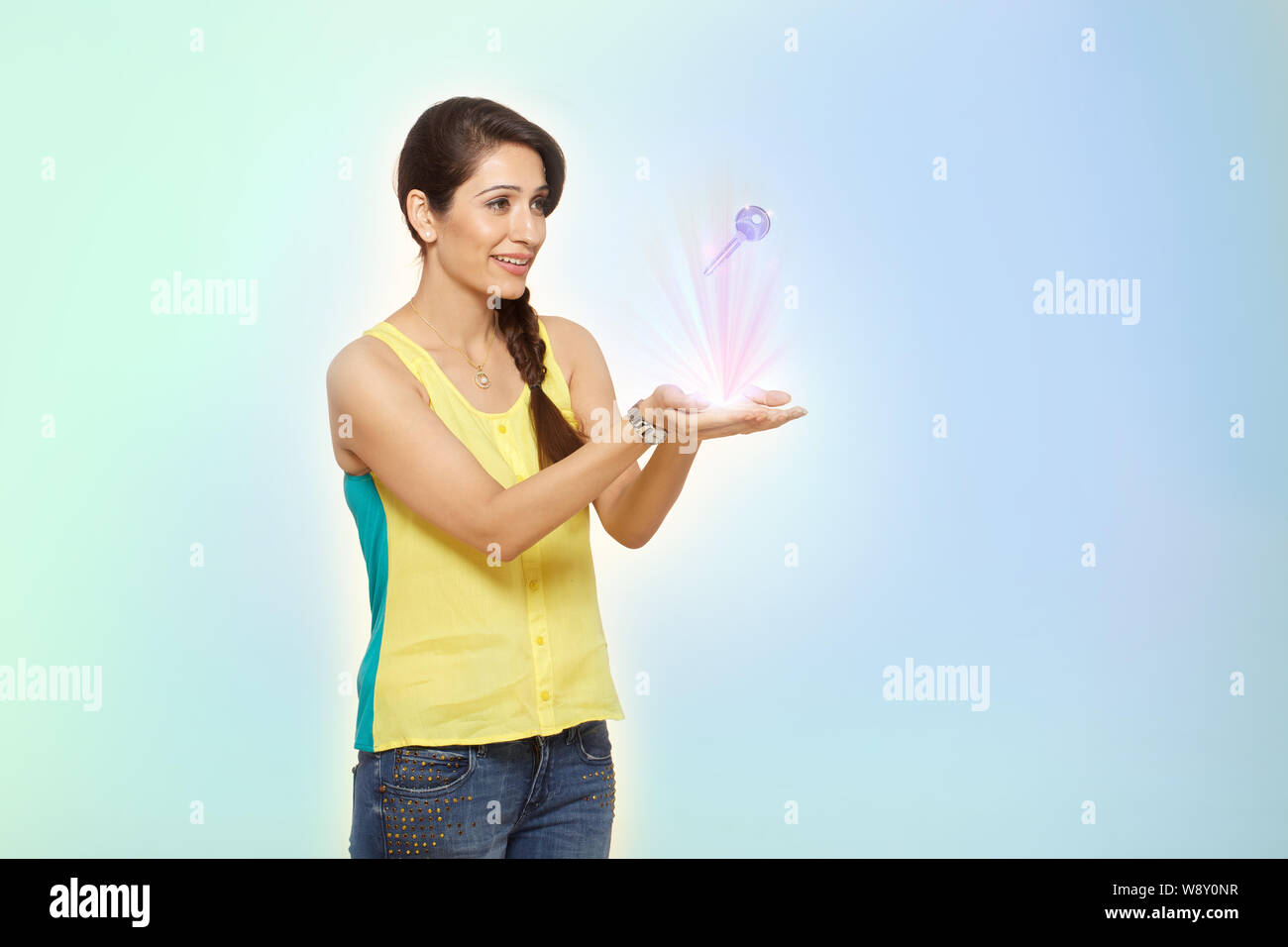 Woman holding a glowing house key and smiling Stock Photo - Alamy