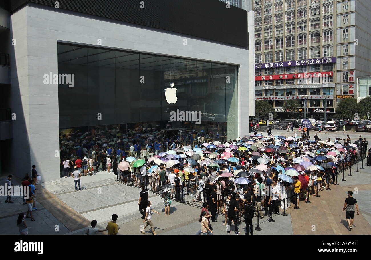 Crowds of people queue up in front of the new Apple Store in Chongqing ...