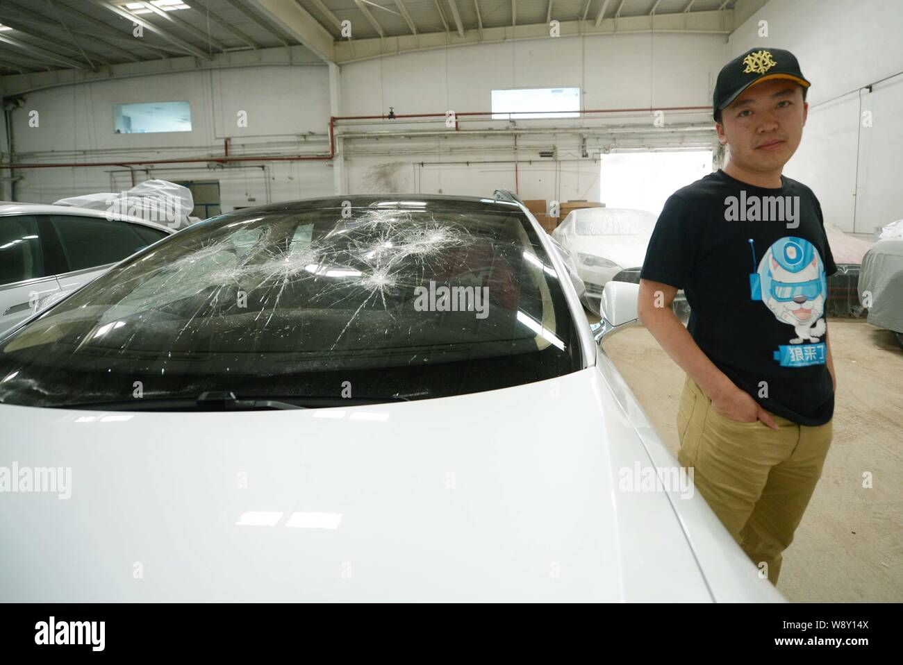 Yu Xinquan stands next to the damaged Tesla Model S he smashed because ...