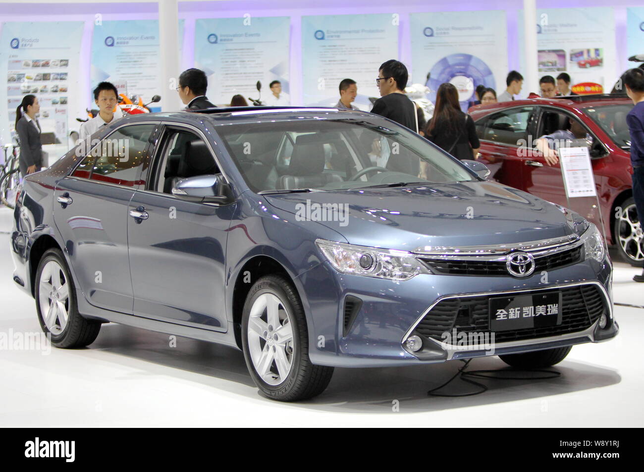 --FILE--Visitors try out or look at Toyota cars on display during the ...