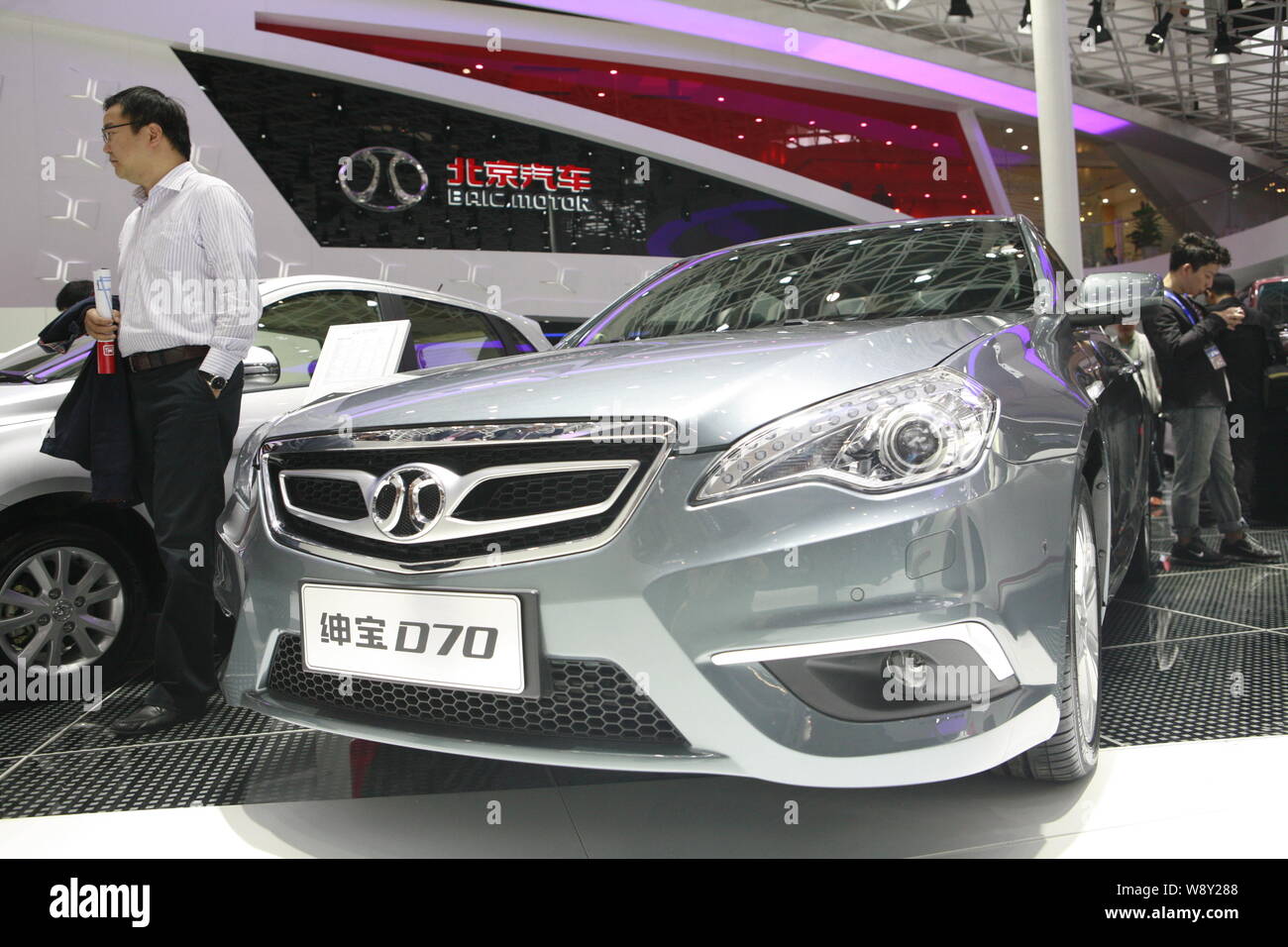 A visitor walks past a Shenbao D70 of BAIC Motor (Beijing Automotive ...