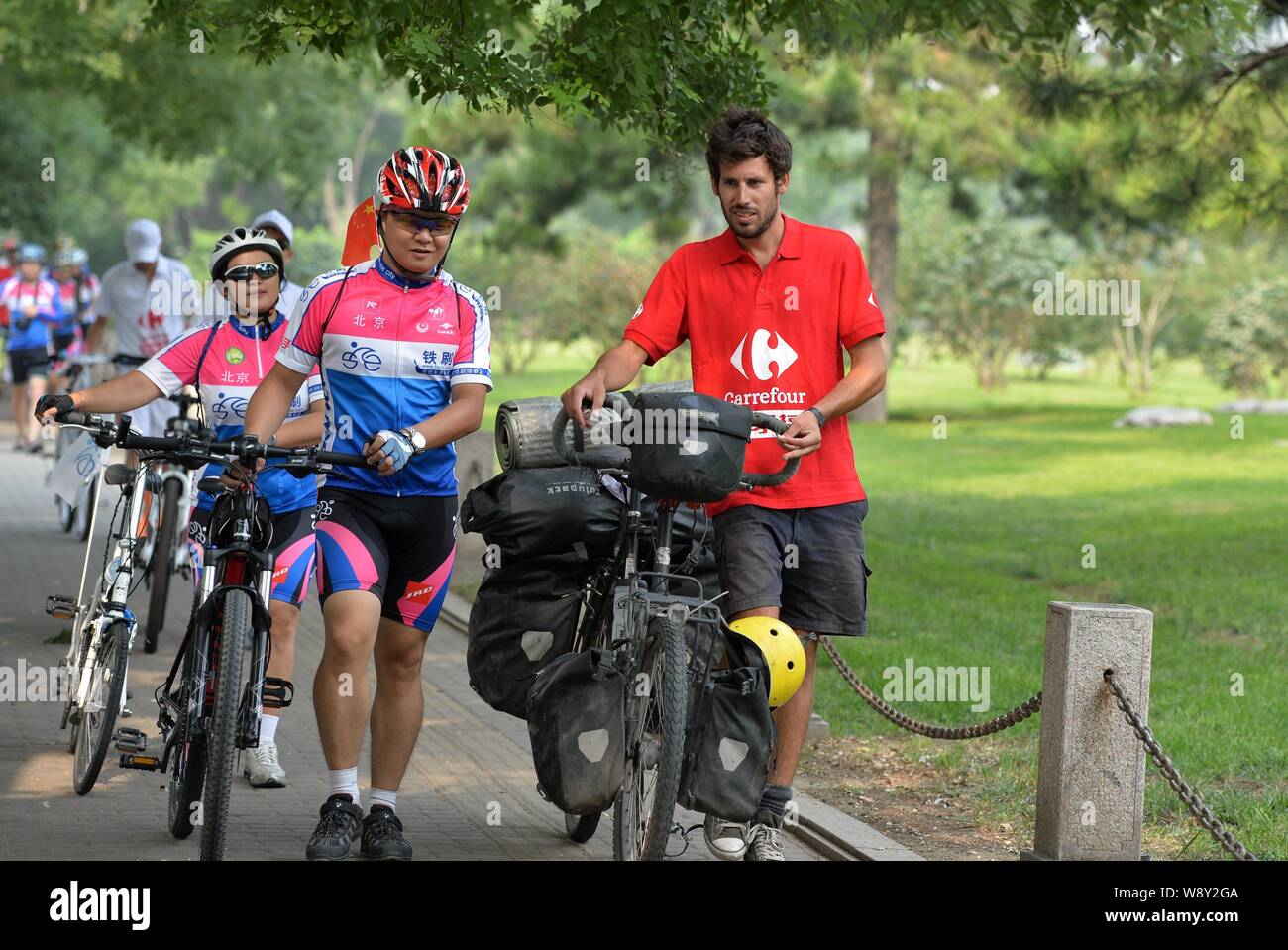 French cyclist Simon Poniard, right, pushes his bike alongside with ...