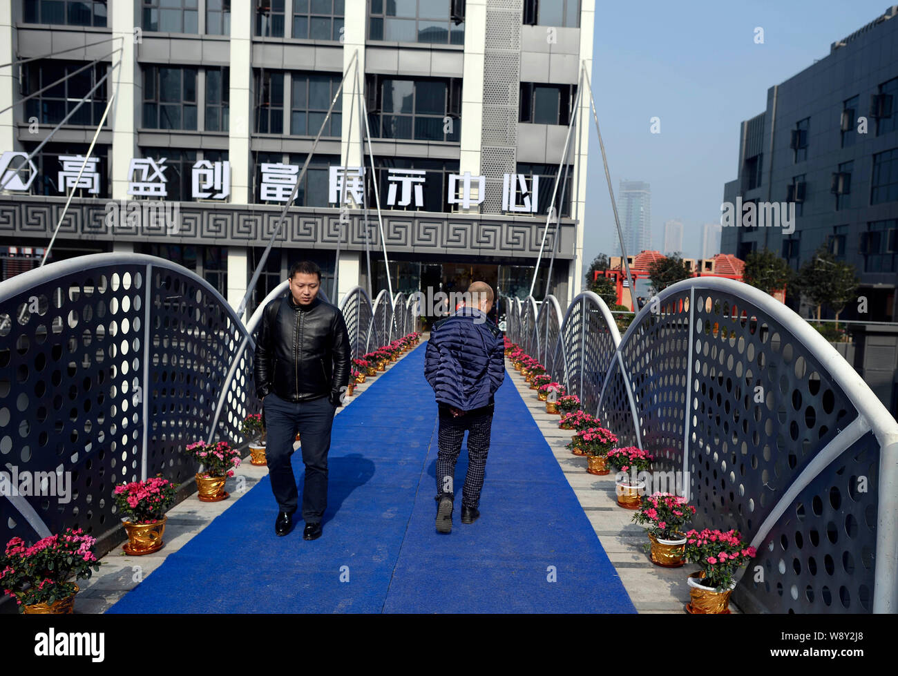 Pedestrians walk on one of the two pedestrian bridges sticking out from ...
