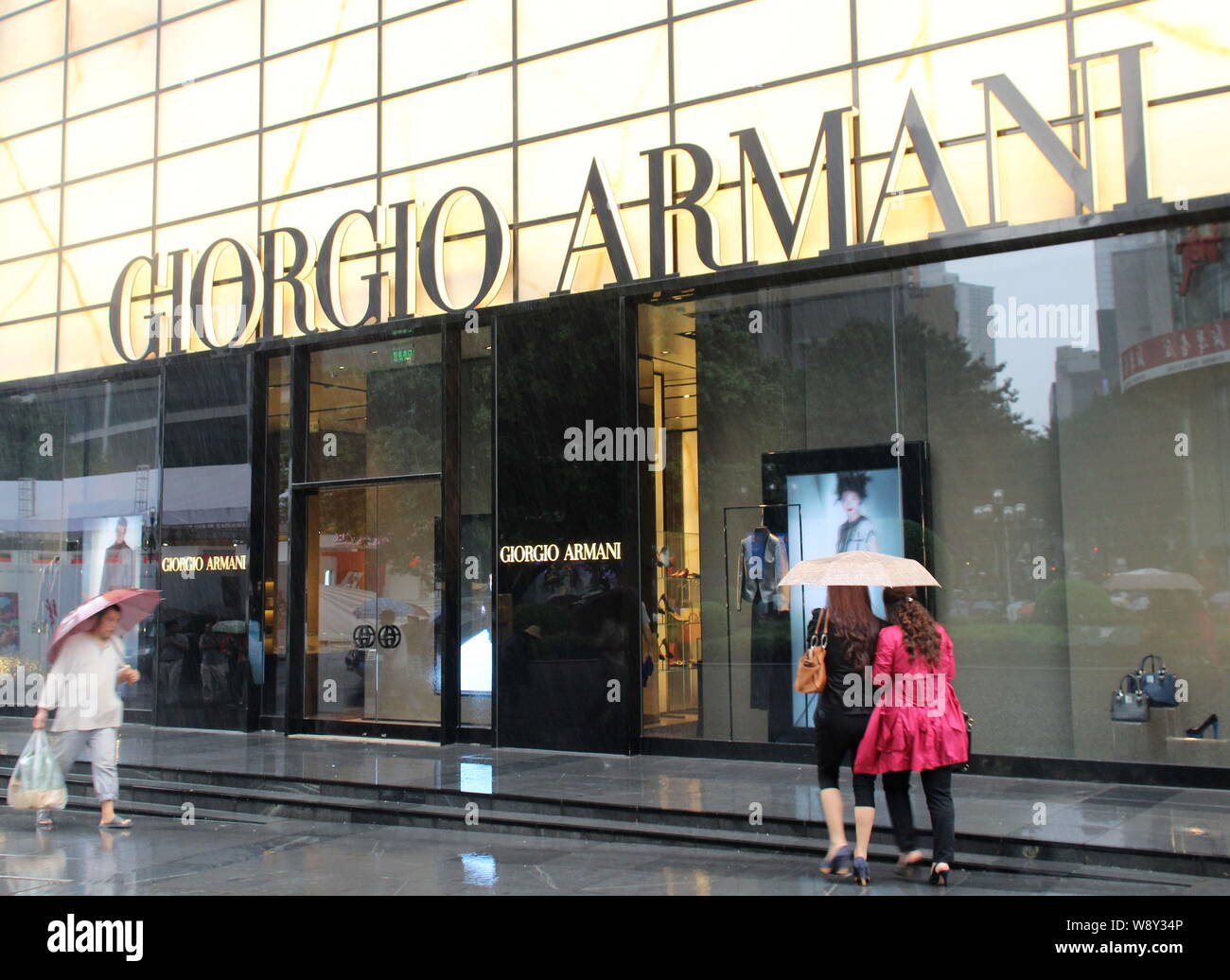 --FILE--Pedestrians walk past a Giorgio Armani store in Chongqing ...