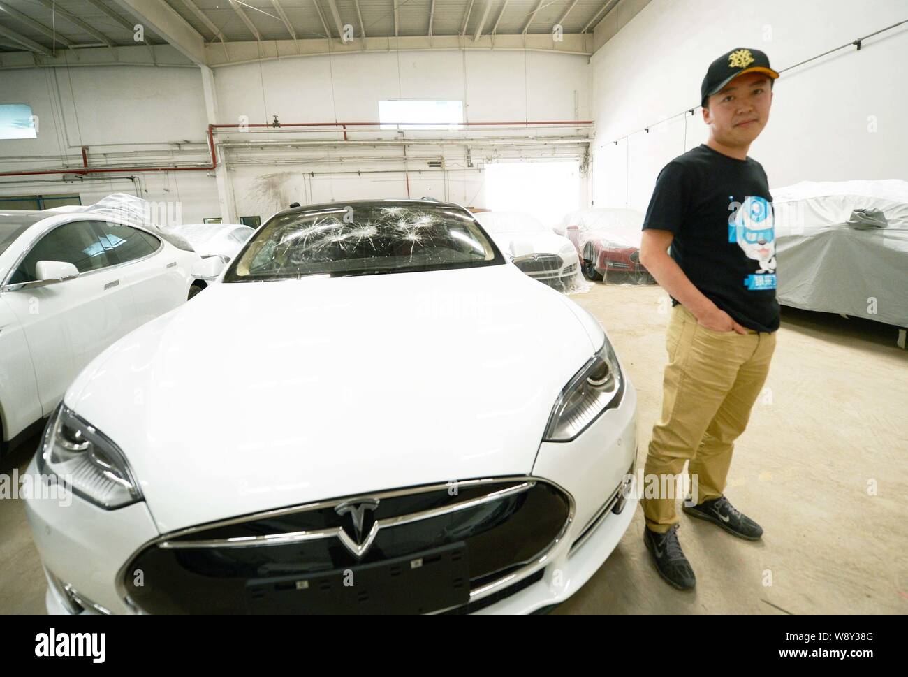 Yu Xinquan stands next to the damaged Tesla Model S he smashed because ...