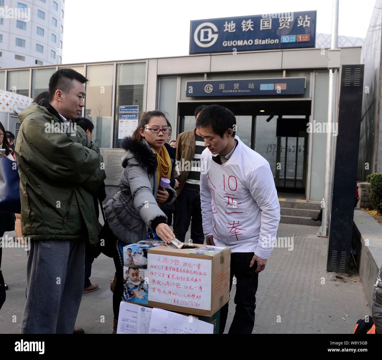 A pedestrian donates to Xia Jun, whose two-year-old son was diagnosed ...