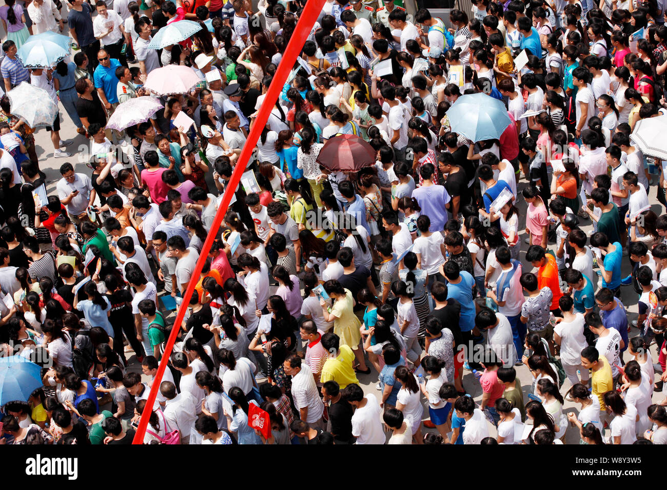 A crowd of Chinese students exit a school after finishing the first ...