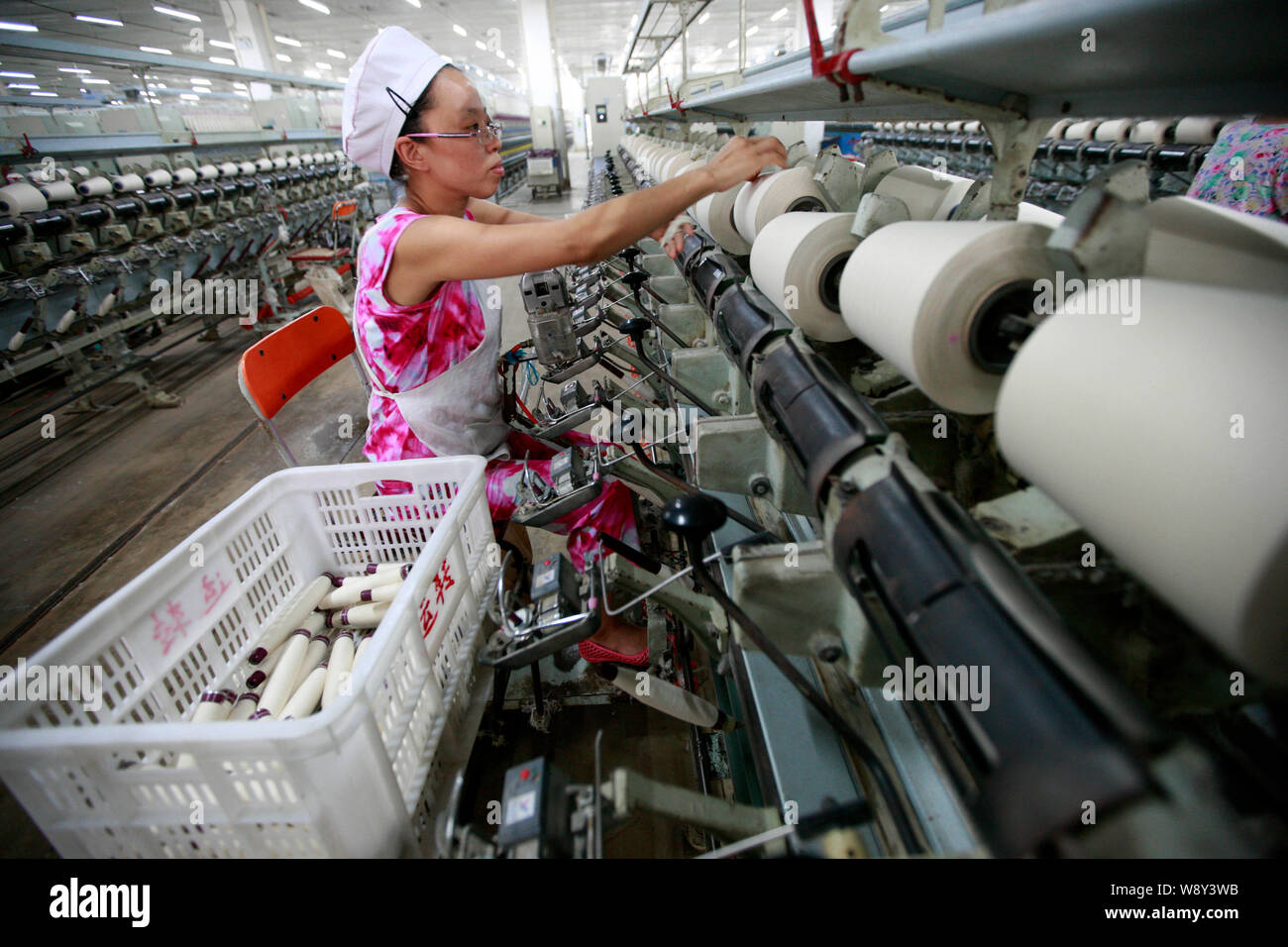 --FILE--A female Chinese worker handles production of yarn to be exported to South Korea at a ...