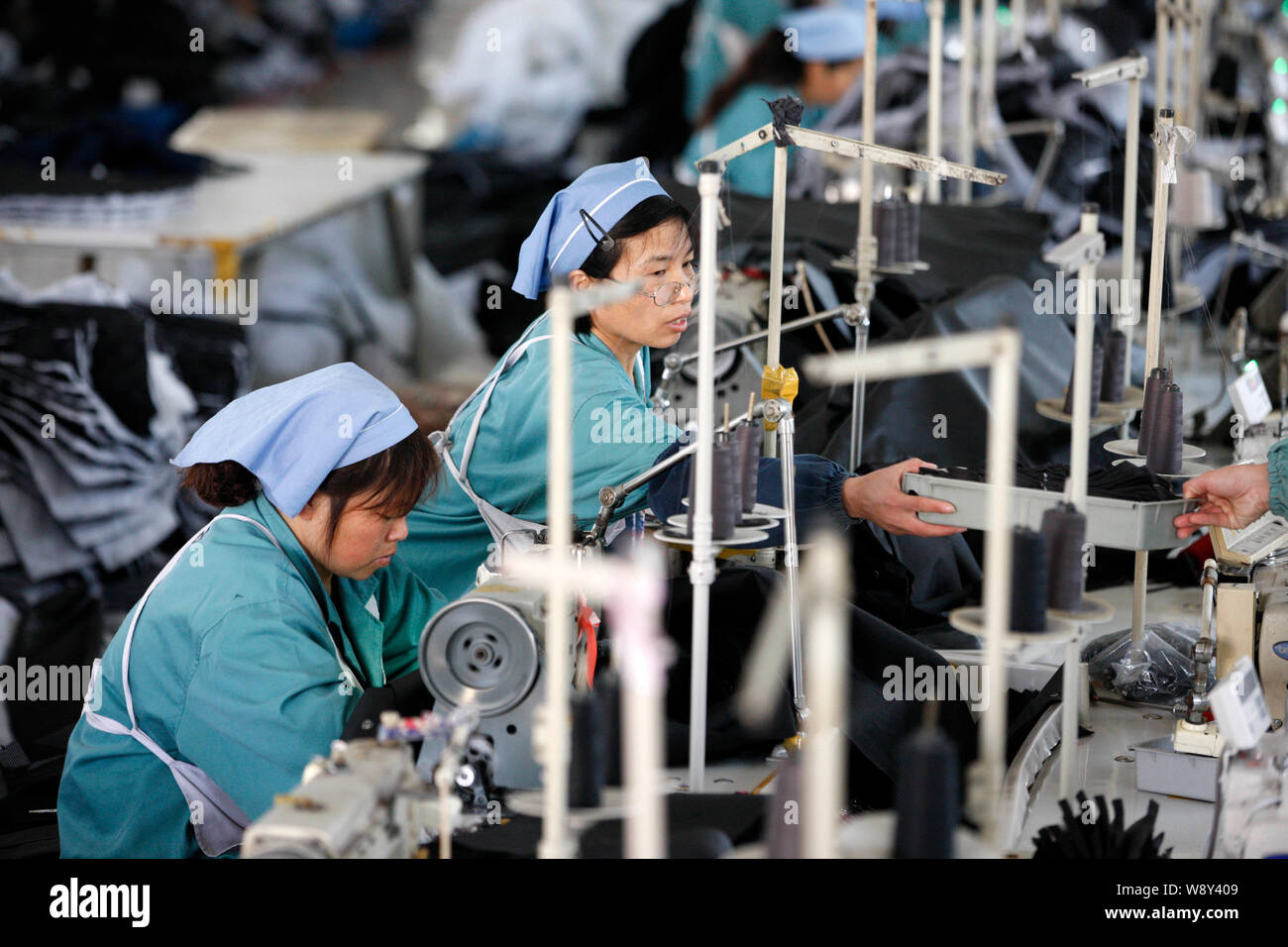 Female Chinese workers sew clothes to be exported to Germany at a garment factory in Huaibei ...