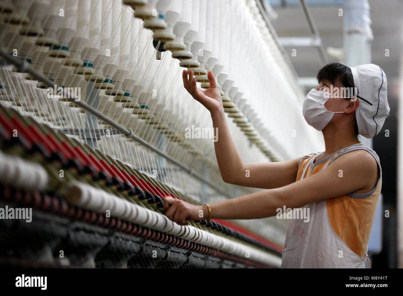 --FILE--A female Chinese worker handles production of yarn to be exported to South Korea at a ...