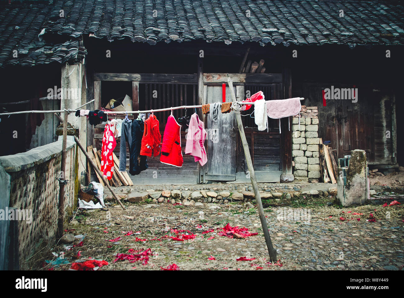 Local Chinese residents use a bamboo pole to air out clothes in front ...